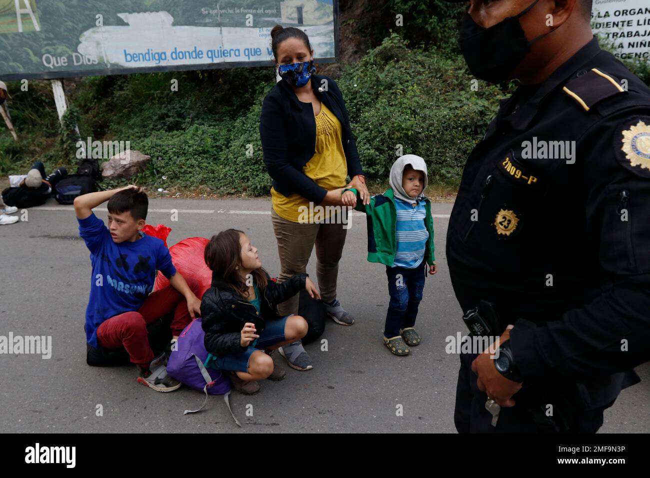 Migrants hoping to reach the distant U.S. border rest on a highway where police patrol in ...