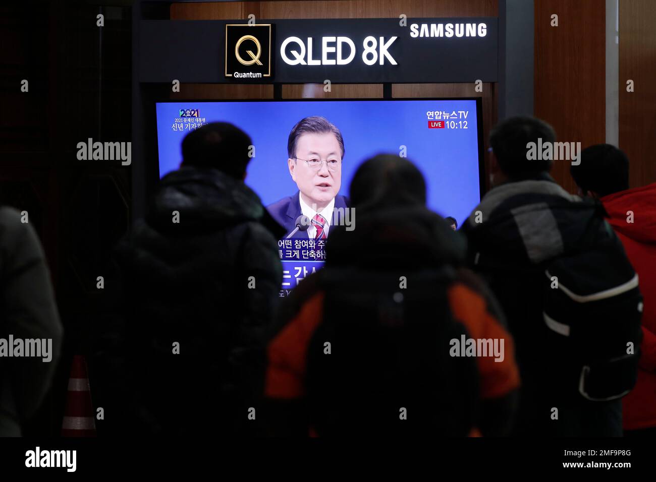People watch a TV screen showing the live broadcast of South Korean ...