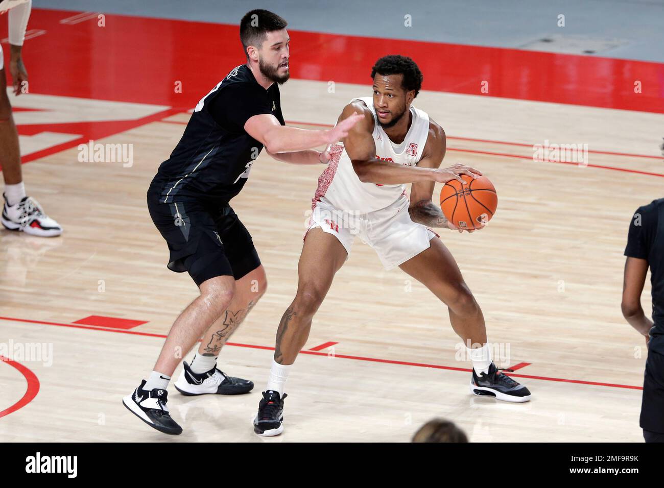 Houston forward Justin Gorham, right, looks to pass the ball under ...
