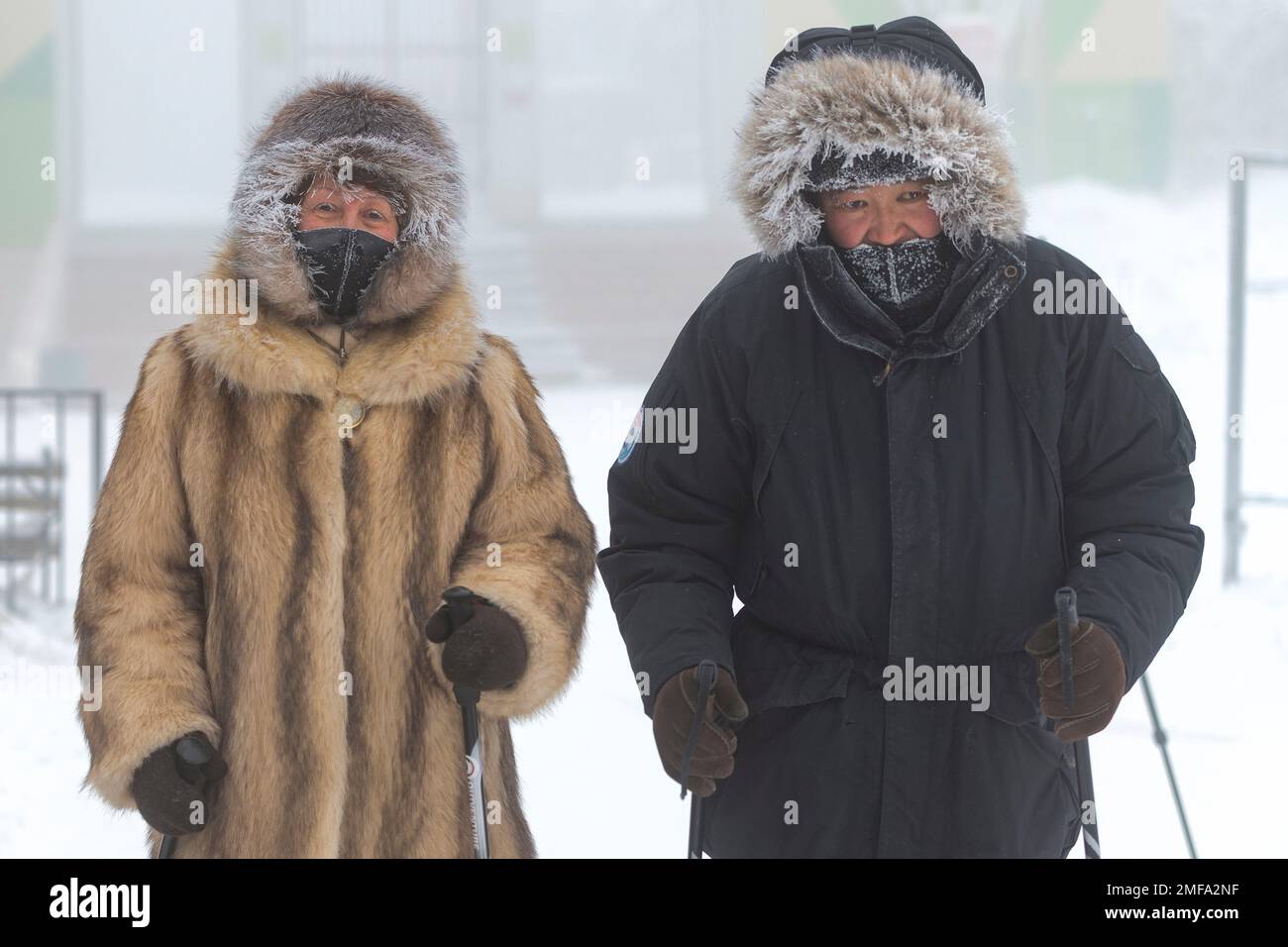 A couple walk in a street as the temperature dropped to about -50 ...