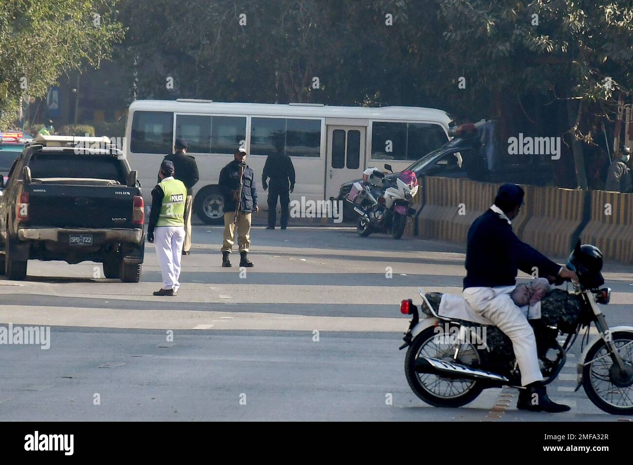 Pakistani police officers stand guard as a mini-bus transporting South ...