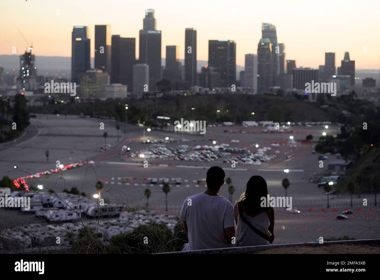 Visitors watch the sunset over a COVID-19 vaccination site at Dodger ...