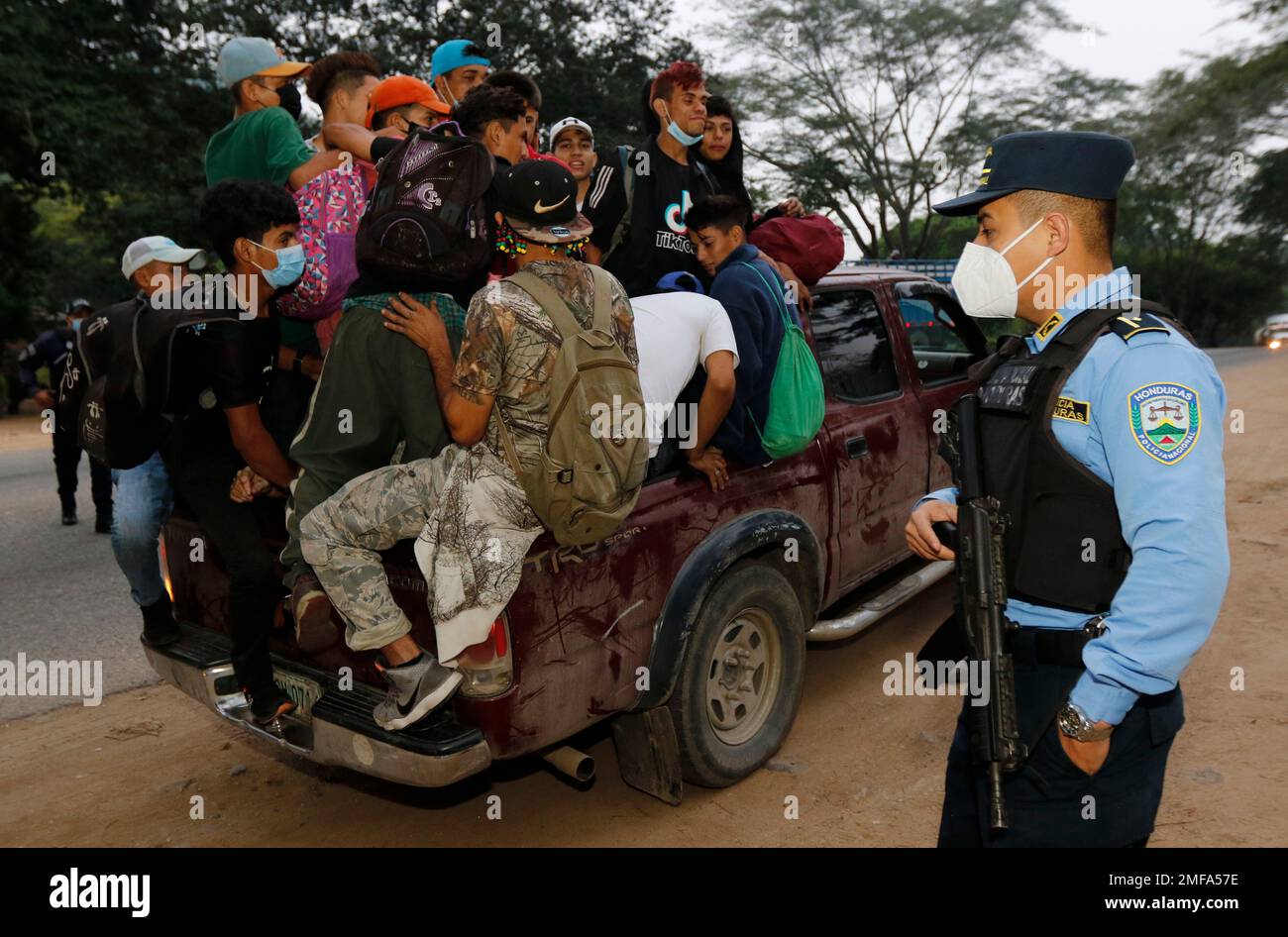 A police officer stands by as travelers fill the back of a truck after ...