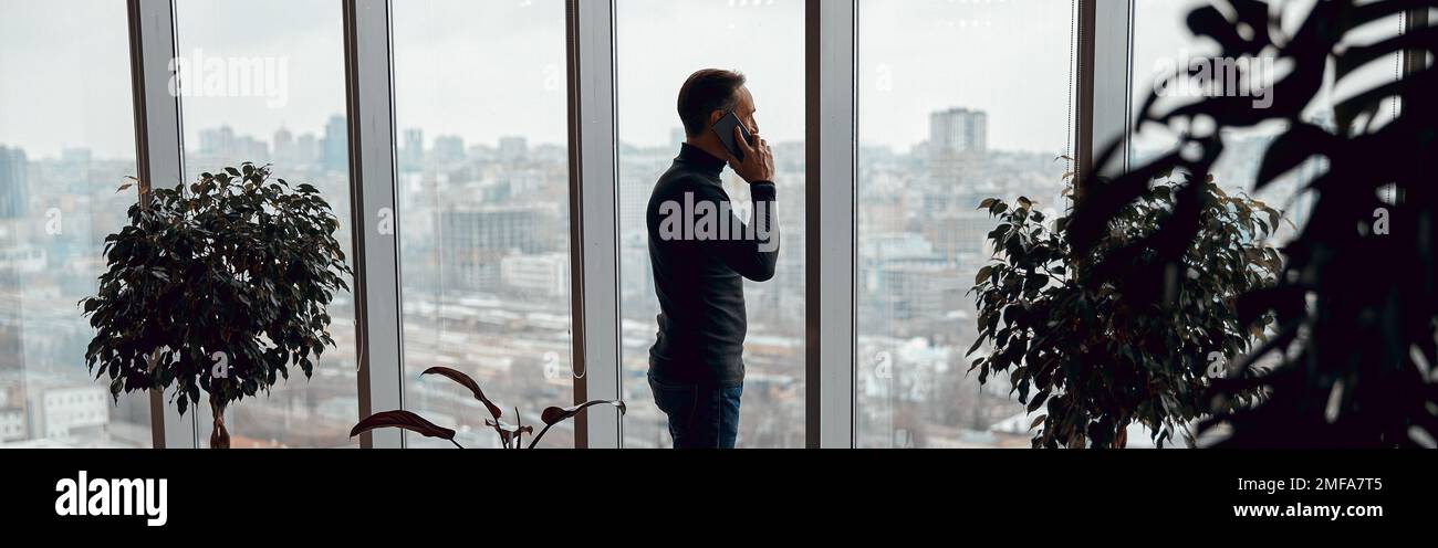 Side view of man using smartphone while talking Stock Photo - Alamy
