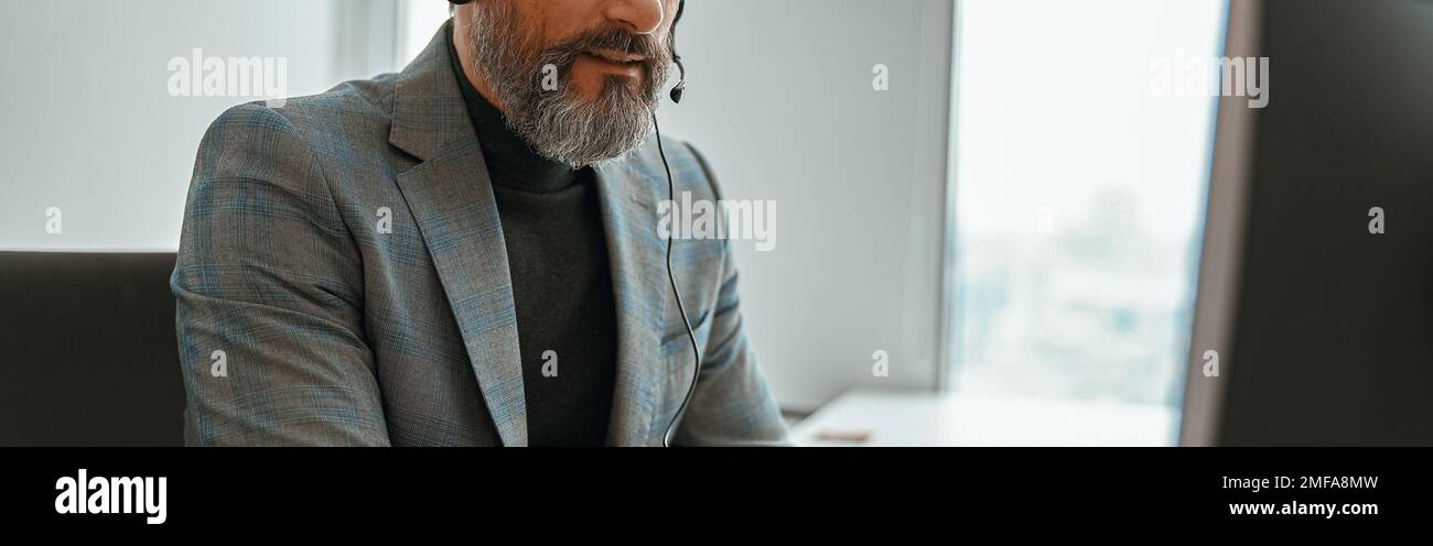 Smiling man is busy while speaking online Stock Photo - Alamy