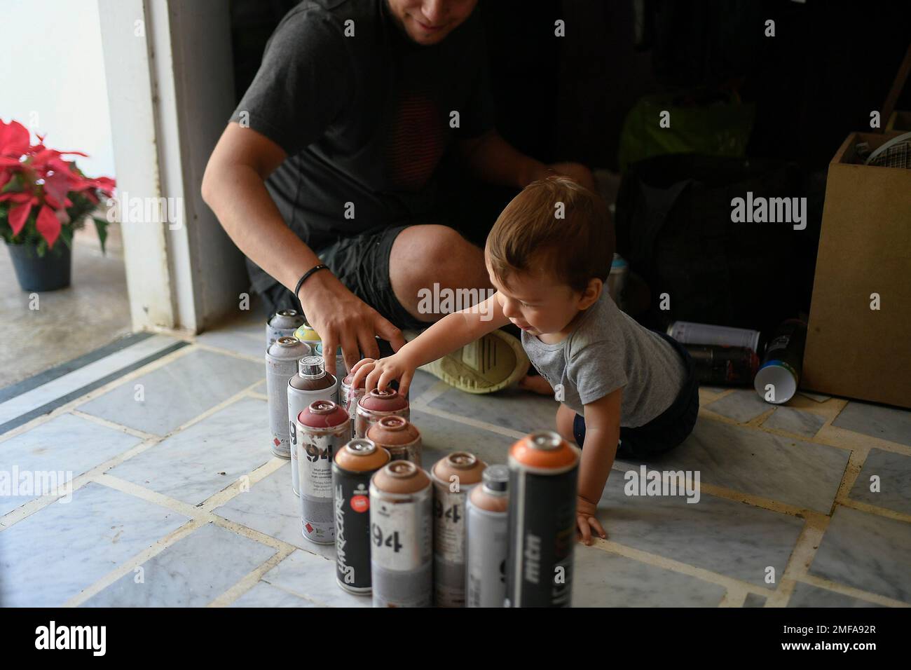 Street artist Wolfgang Salazar takes inventory of his aerosol paints ...