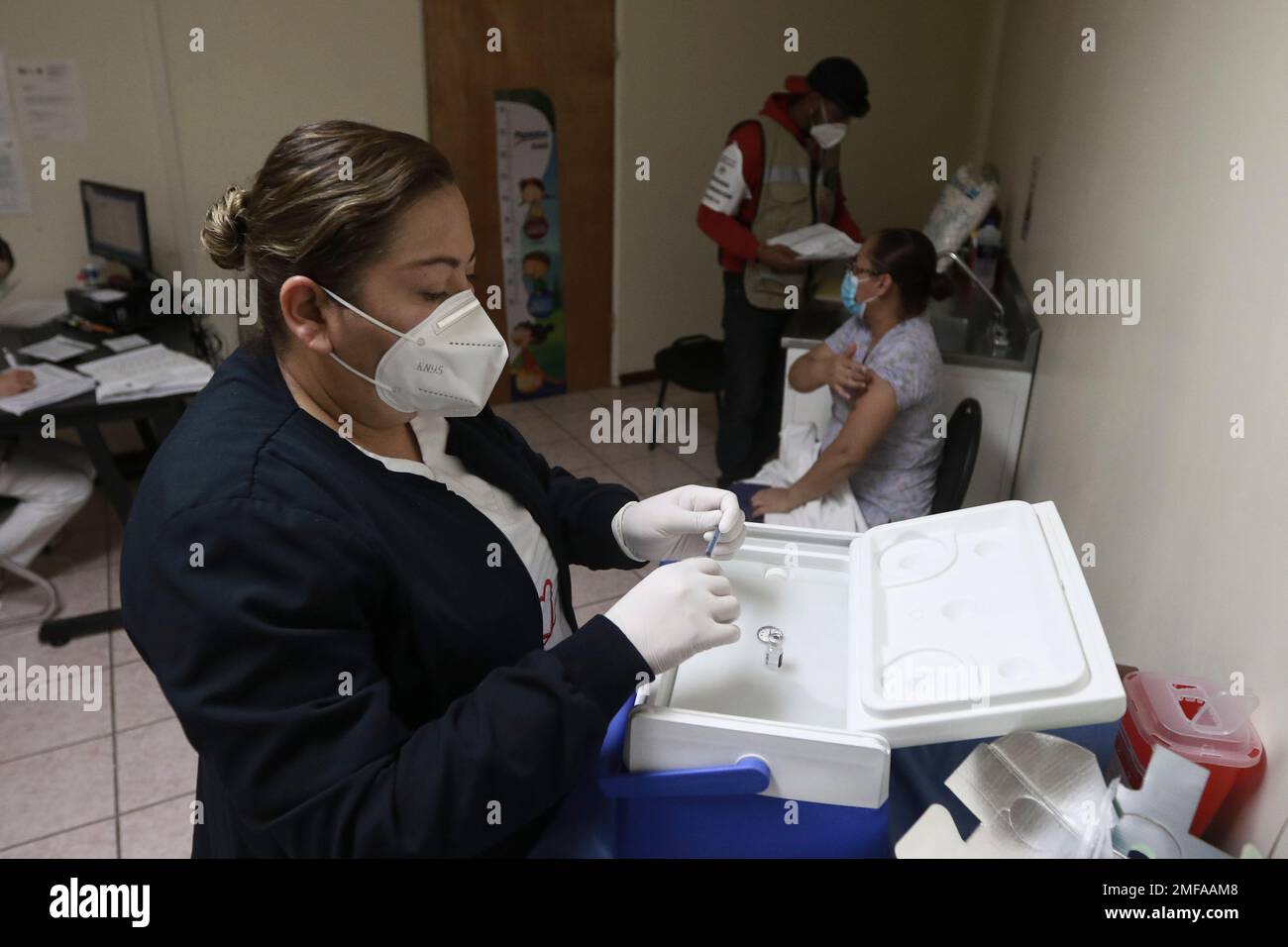 A nurse prepares to apply a shot of the Pfizer vaccine against COVID-19 ...