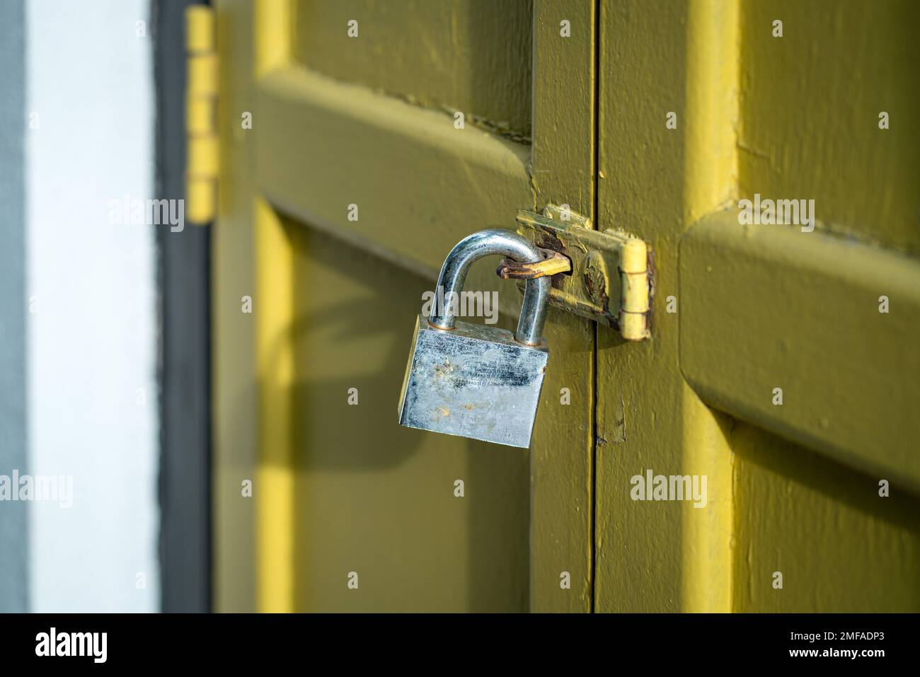 Yellow wood door closed with rusty padlock. Security concept Stock ...