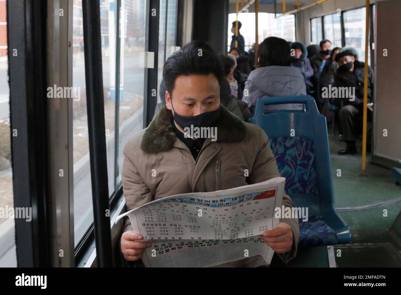 A man checks a newspaper on a trolley bus in Mirae Scientists Street in ...