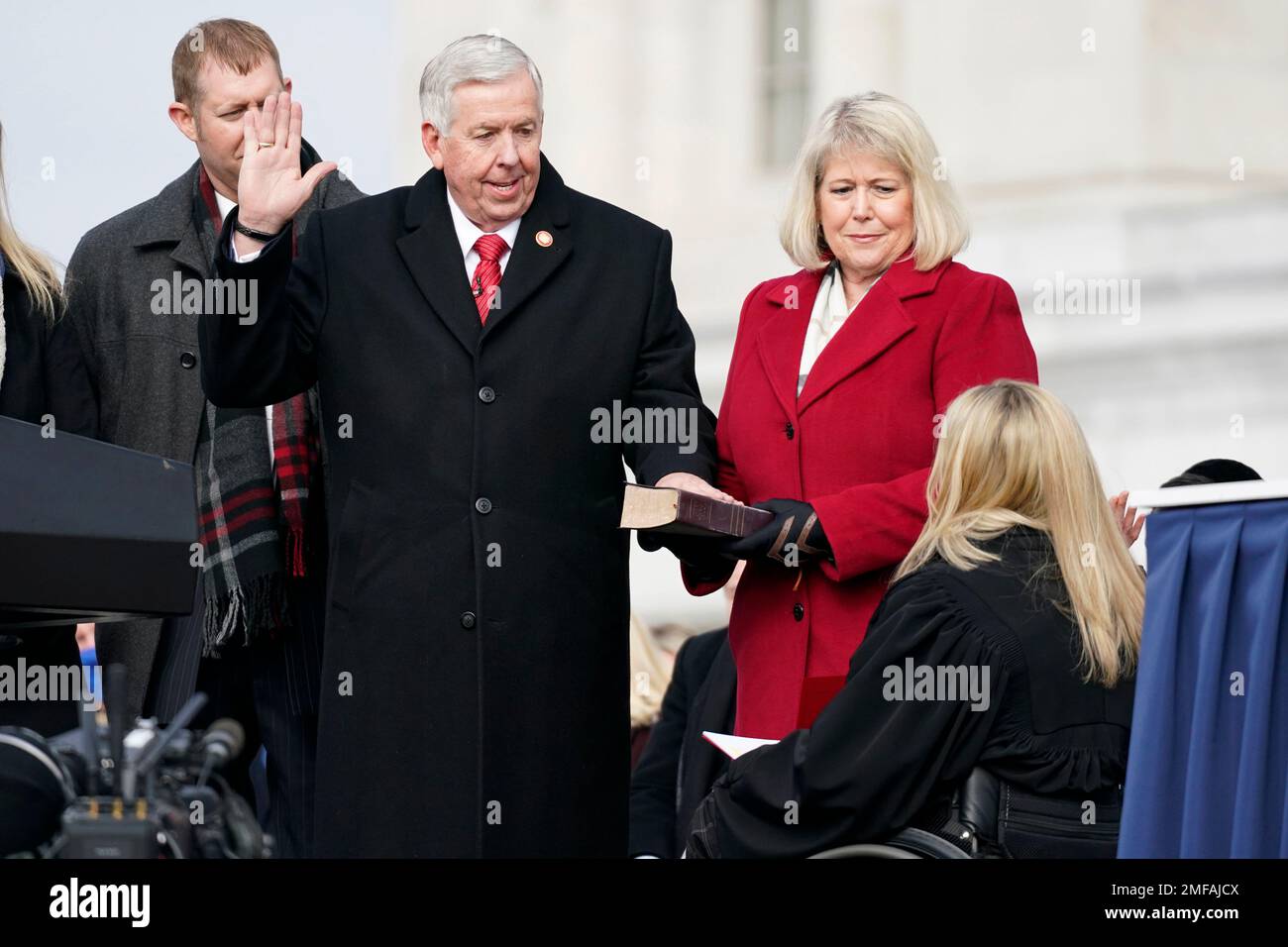 Missouri Gov. Mike Parson takes the oath of office on a bible held by ...