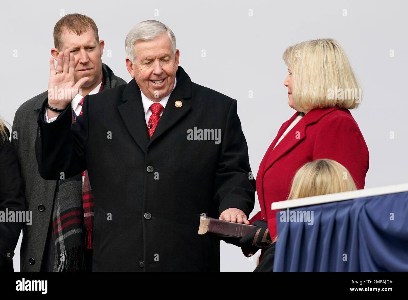 Missouri Gov. Mike Parson takes the oath of office on a bible held by ...