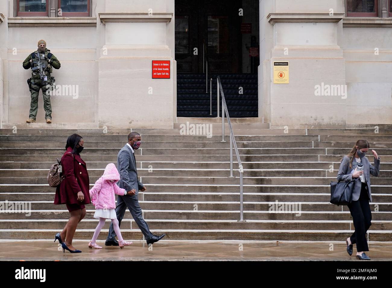 A member of the Georgia State Patrol SWAT team looks on as people walk ...
