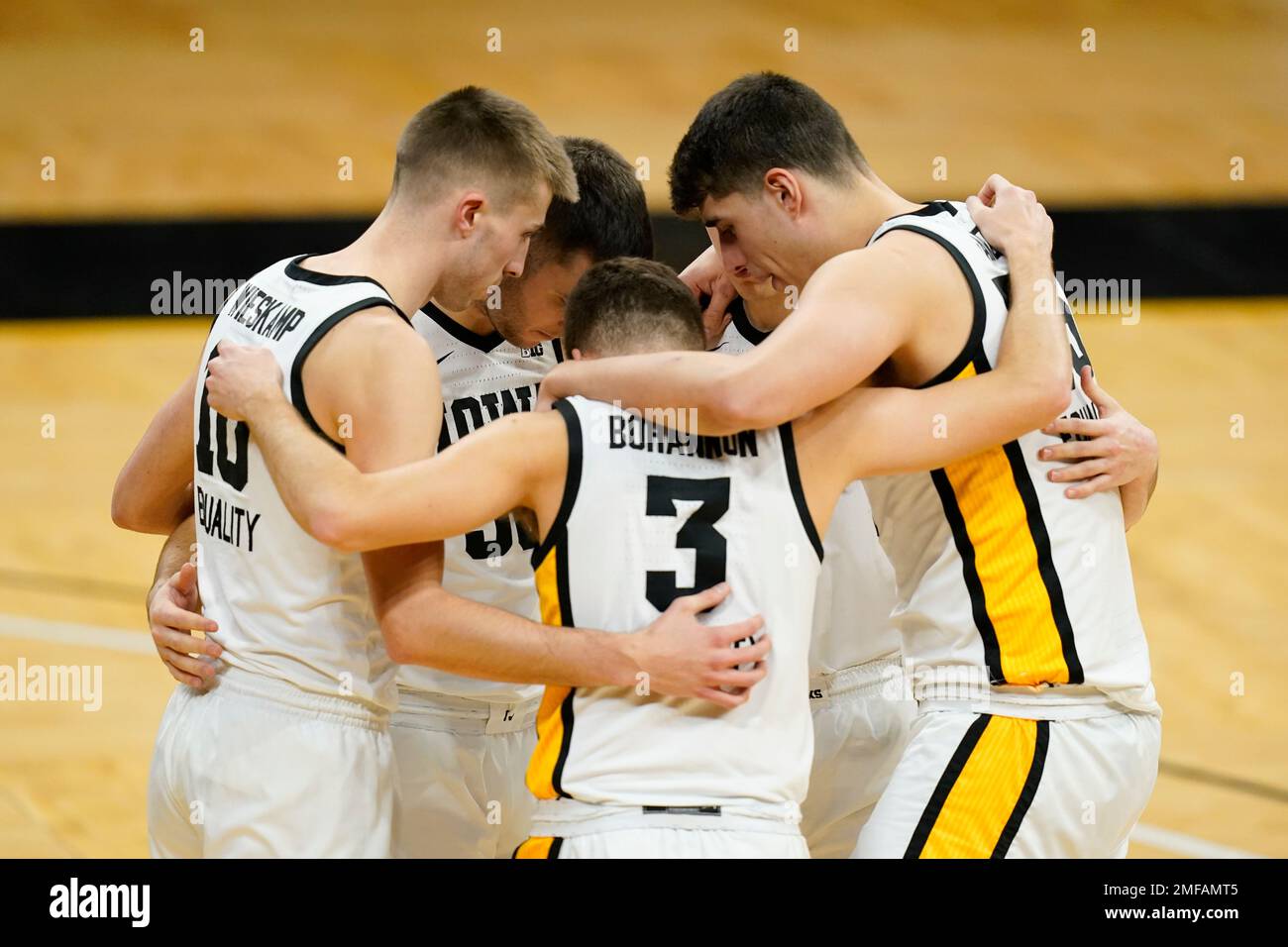 Iowa players huddle on the court before an NCAA college basketball game ...
