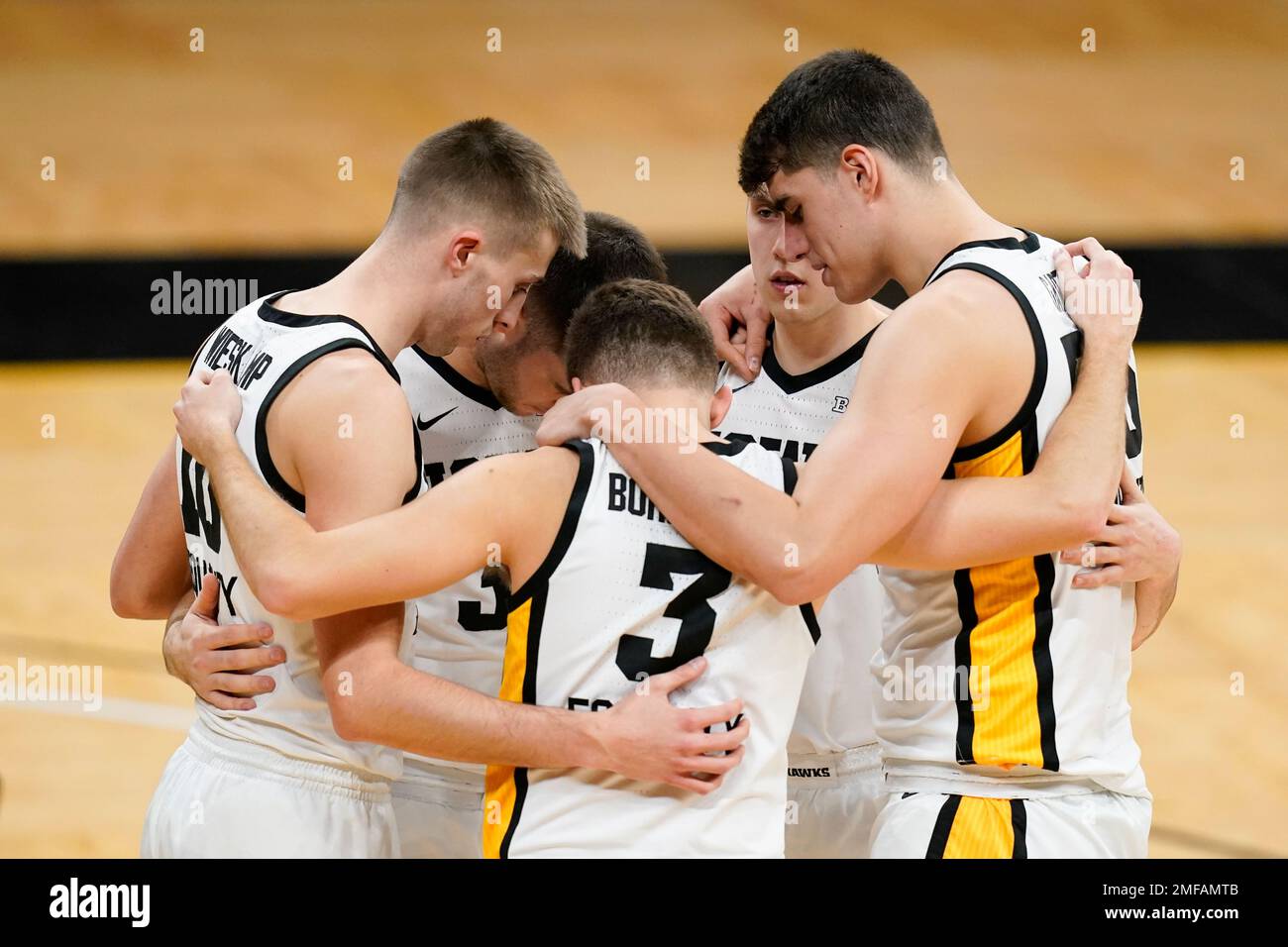 Iowa players huddle on the court before an NCAA college basketball game ...