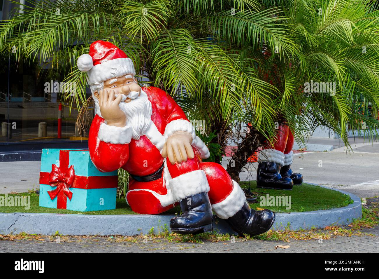 santa claus sitting on the edge of the asera next to a gift box Stock ...