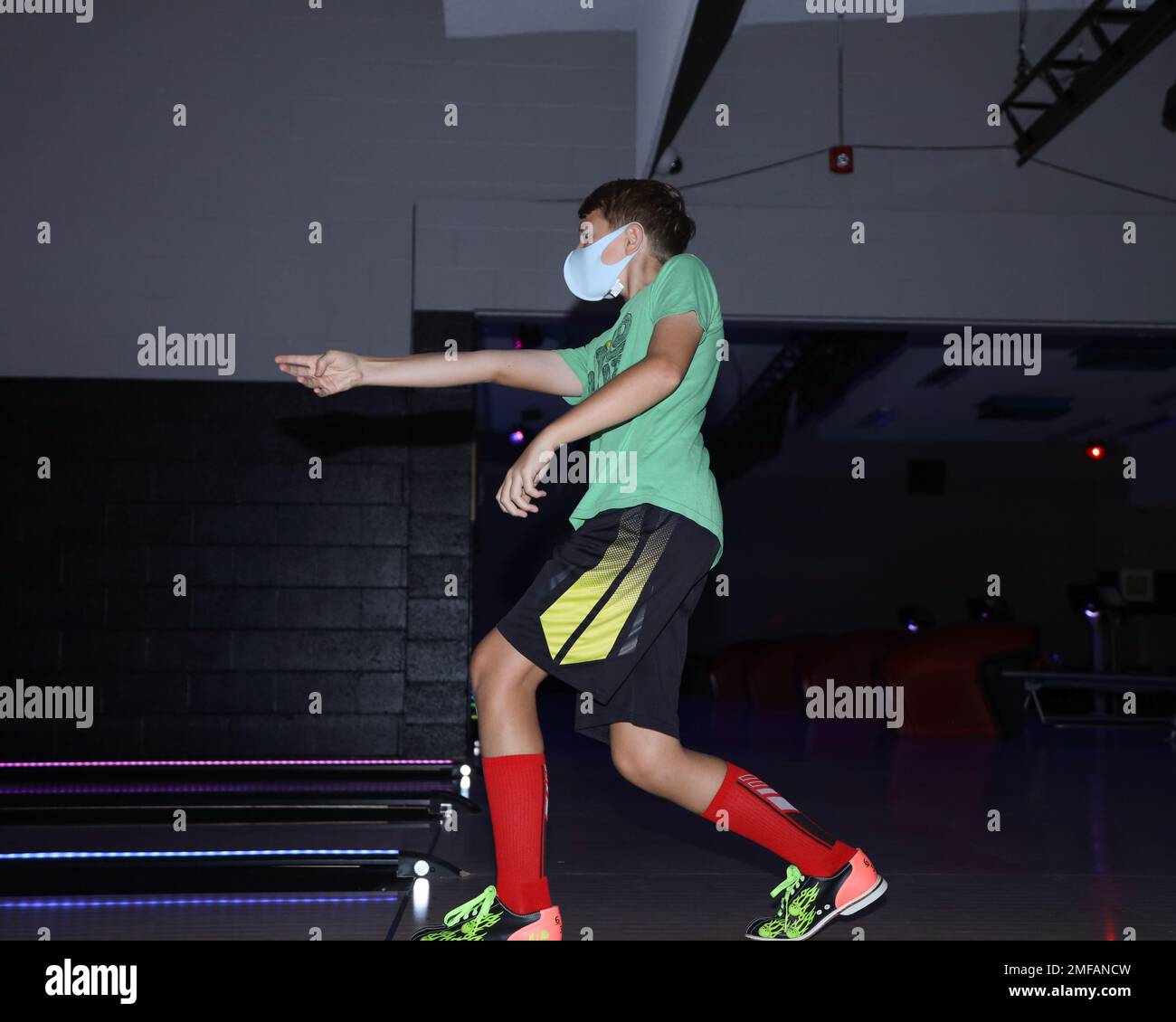 Joey Hodge, a family member on base, throws a bowling ball during the ...