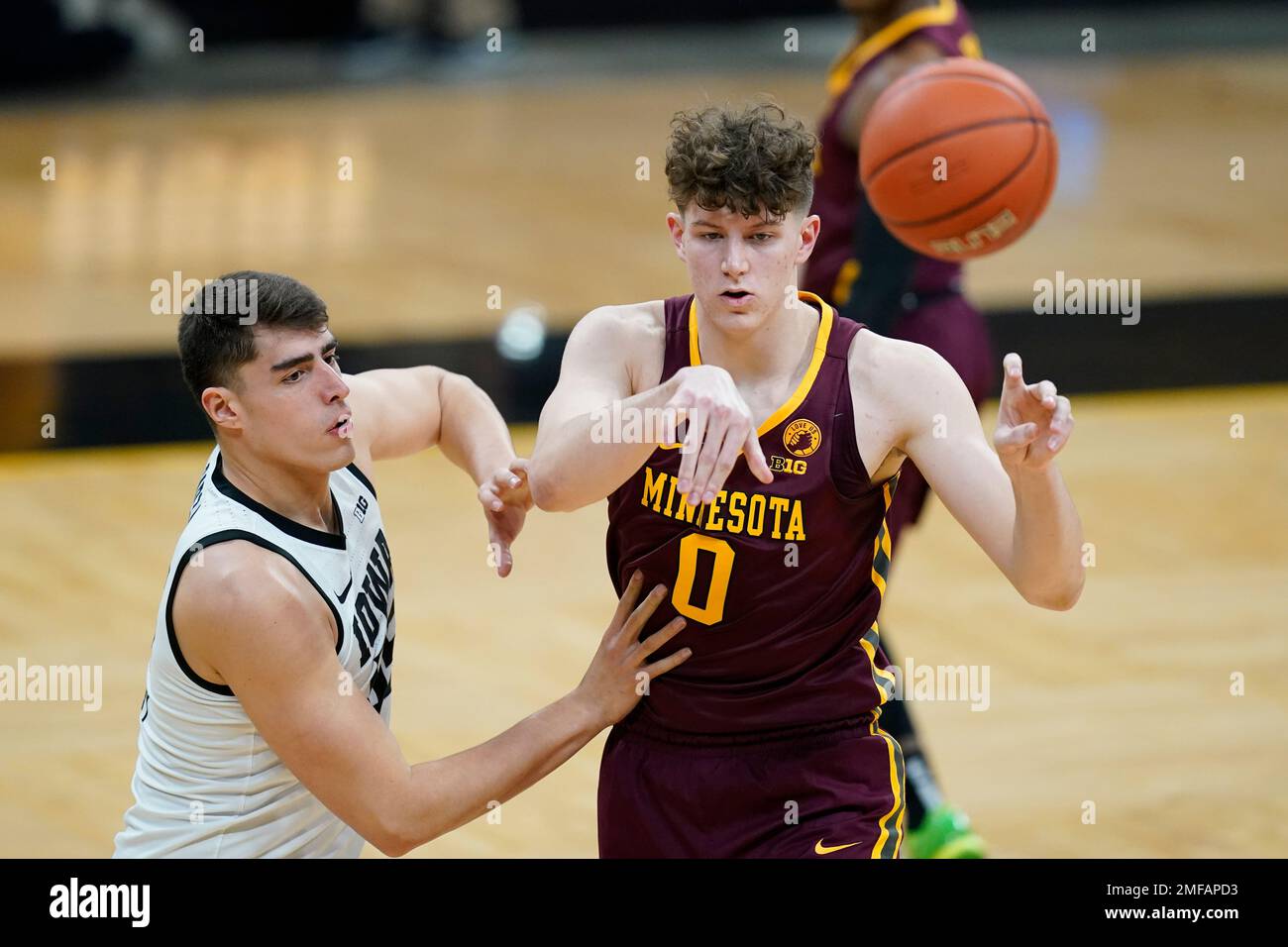 Minnesota center Liam Robbins (0) passes over Iowa center Luka Garza ...