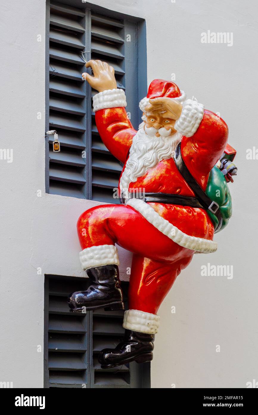 Santa Claus climbing through the windows Stock Photo - Alamy
