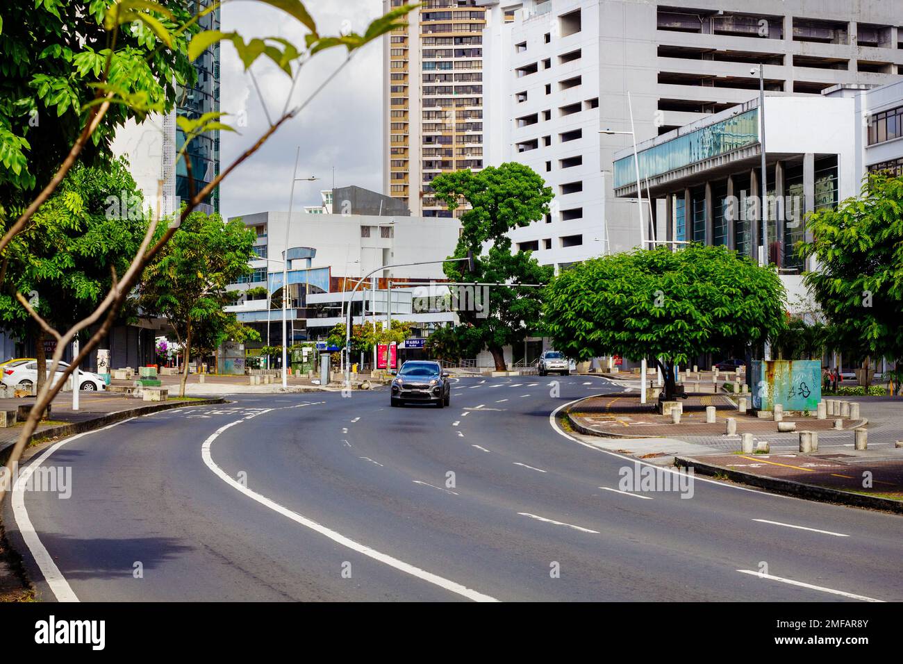 4-way street with trees on the sidewalk and few cars circulating Stock ...