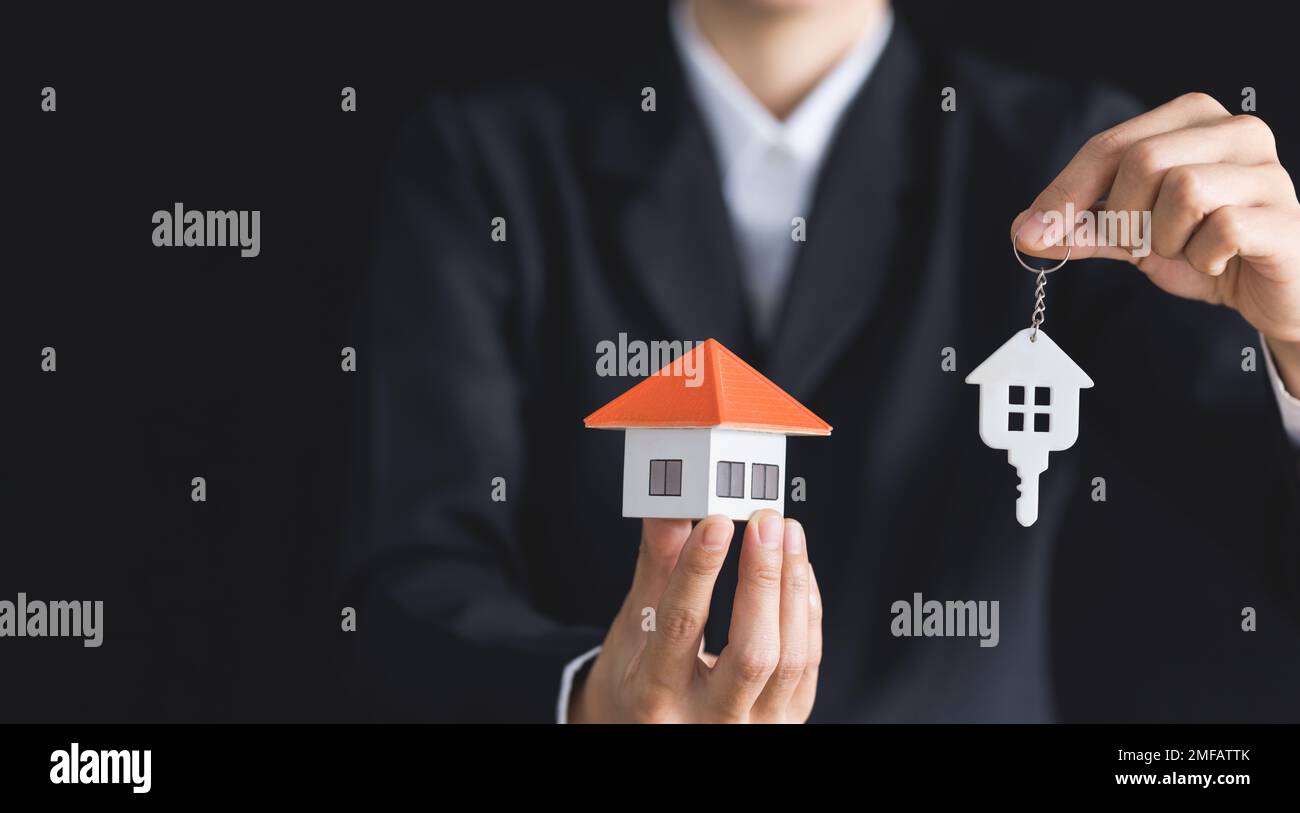 Real estate investors hold home models in hands. Saving plan to buy ...