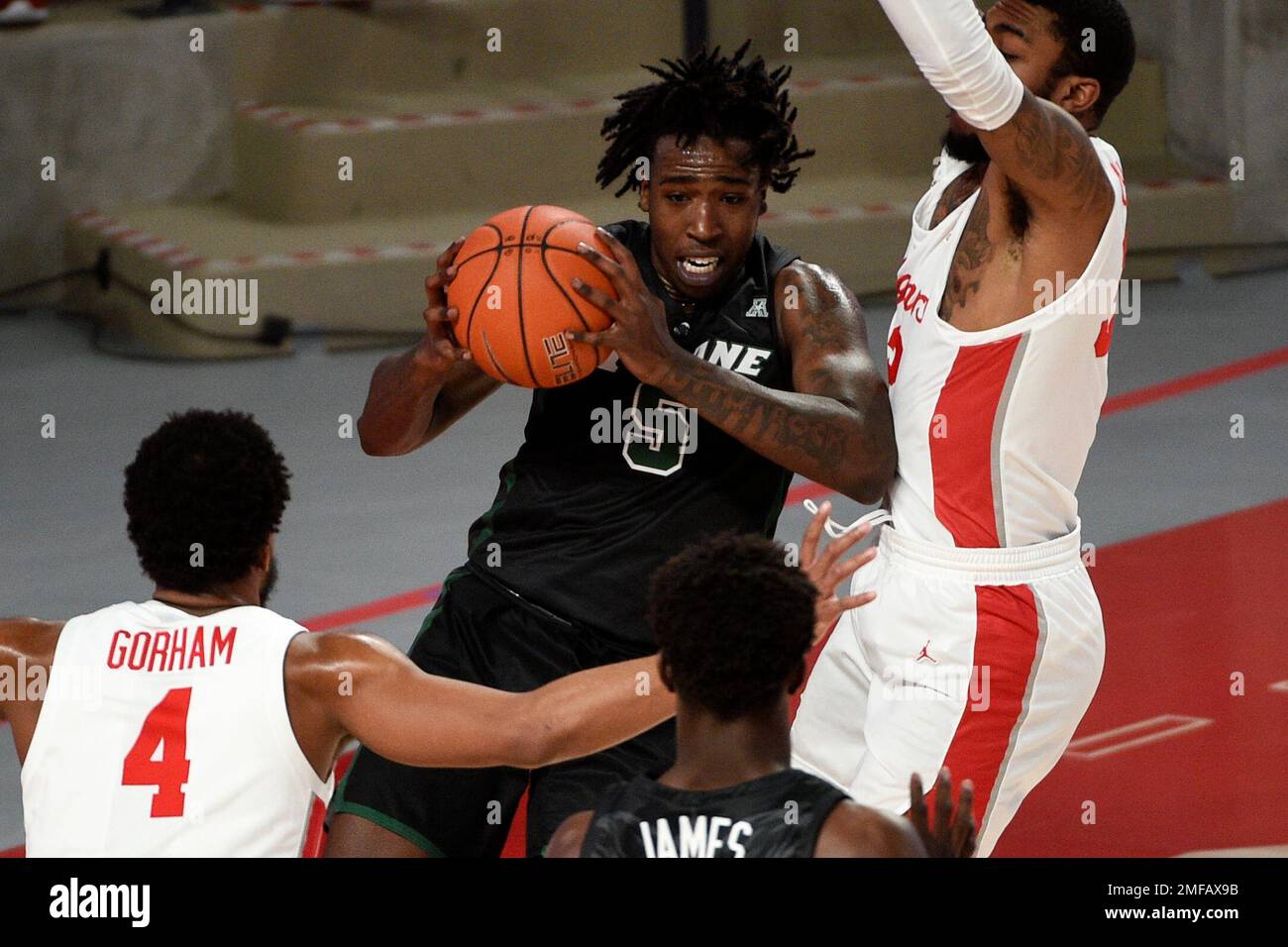 Tulane forward Kevin Cross (5) looks to pass as Houston forward Reggie ...