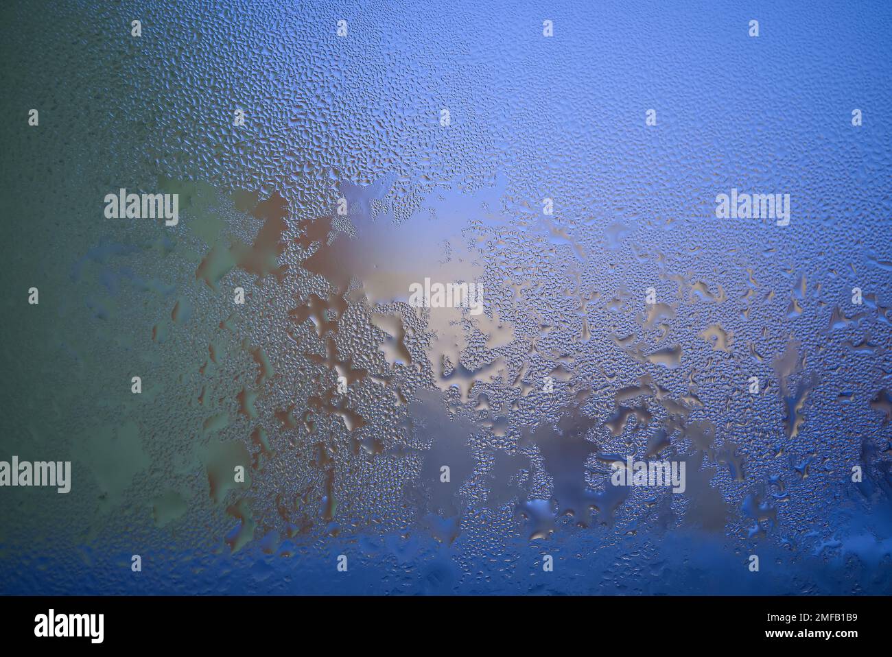 Water droplets or condensation on the outside of a cold windows in a close up full frame ...