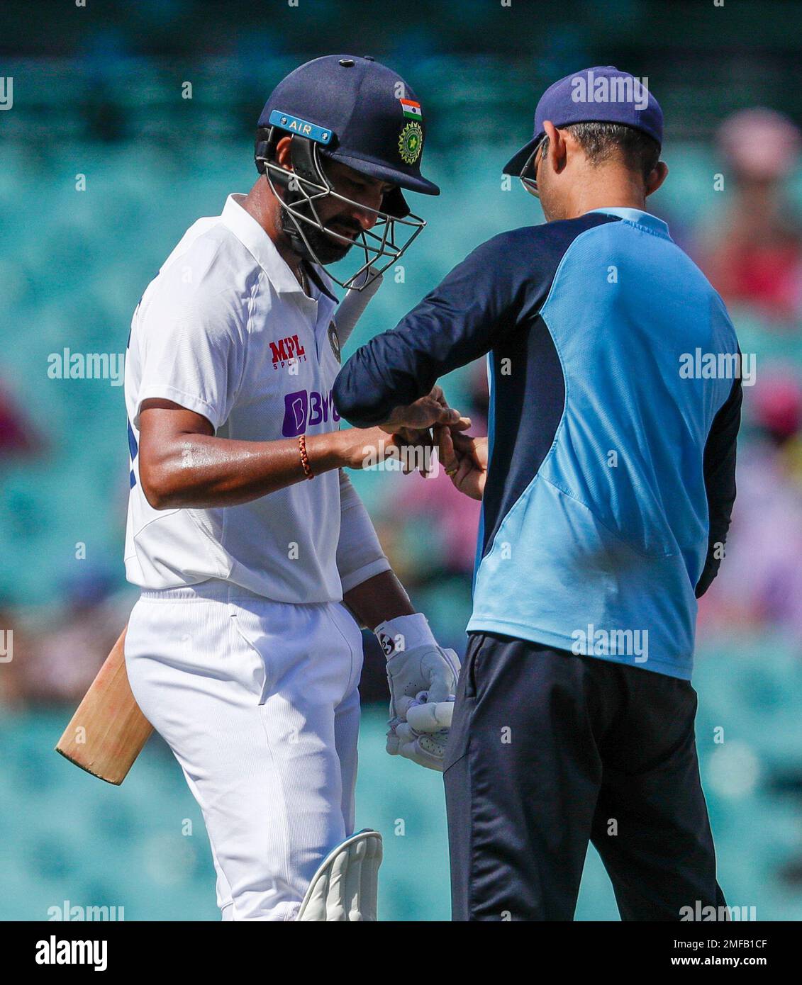 India's Cheteshwar Pujara, left, has treatment to a finger injury ...