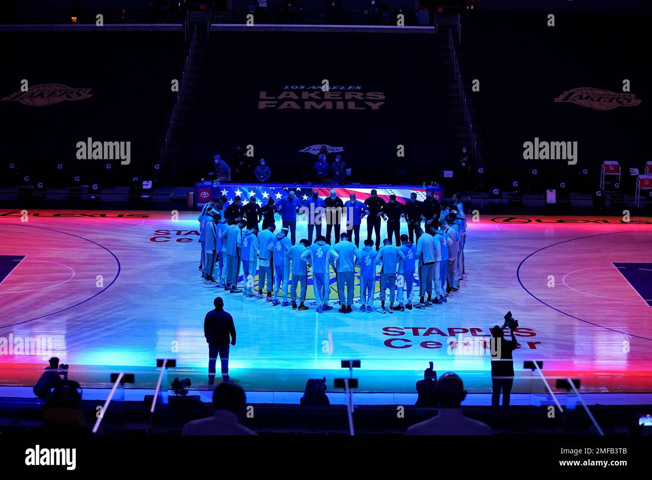 The San Antonio Spurs and the Los Angeles Lakers stand in a circle as ...