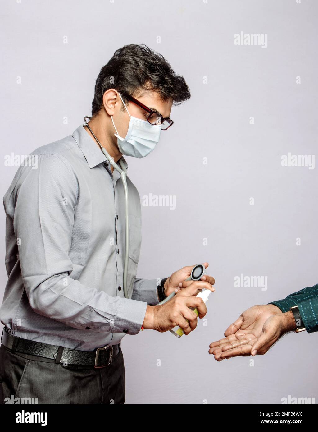 Doctor applying sanitizer on patients hands for disinfection and health ...
