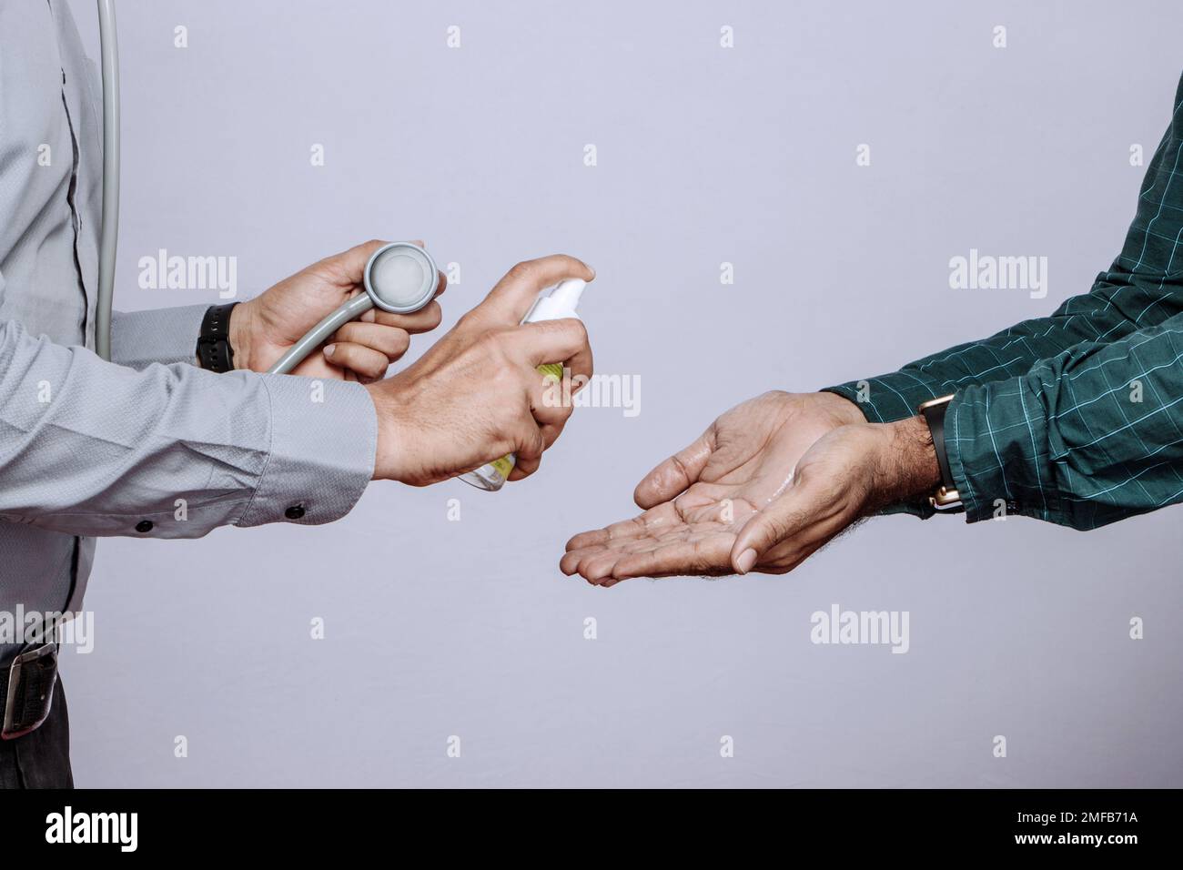 Doctor applying sanitizer on patients hands for disinfection and health ...