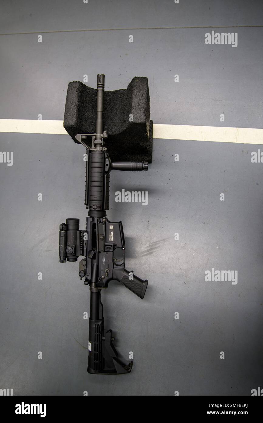 An M4 carbine with the close combat optic scope lays on a rubber block ...