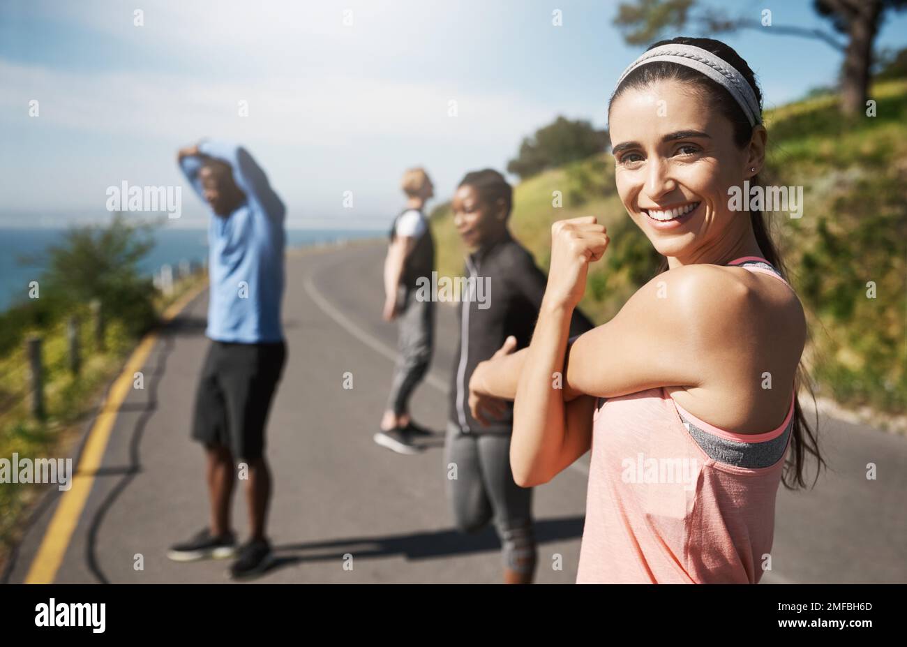 Stretching those muscles for a better run. Portrait of a young woman ...