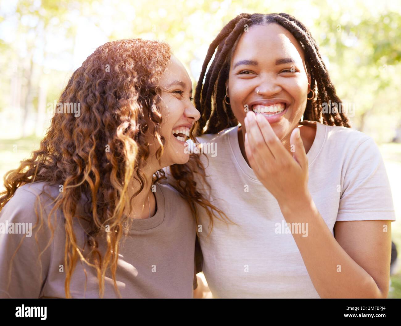 Young women and friends with funny joke laugh together in park for ...