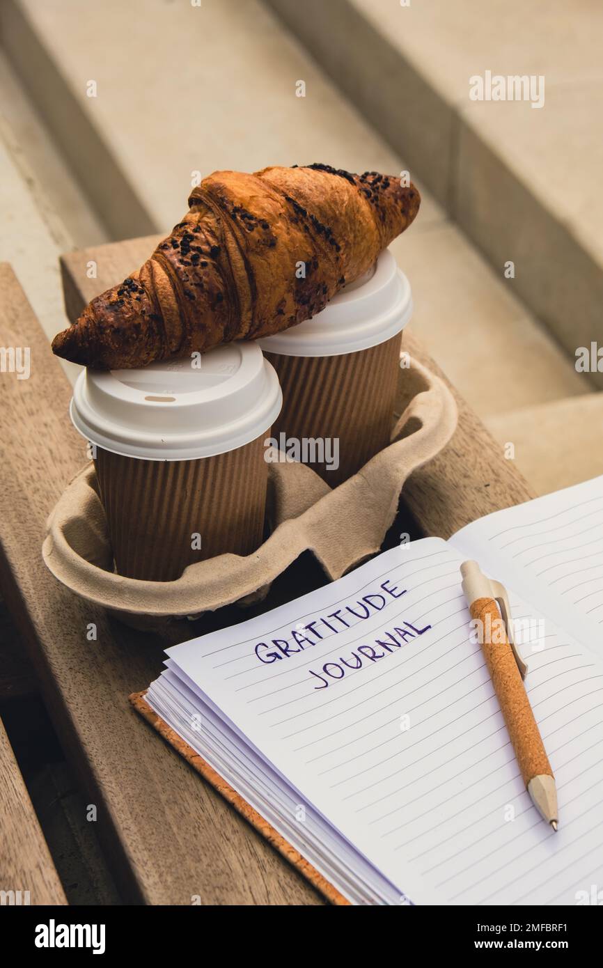 Writing Gratitude Journal on wooden bench. Coffee and croissants ...