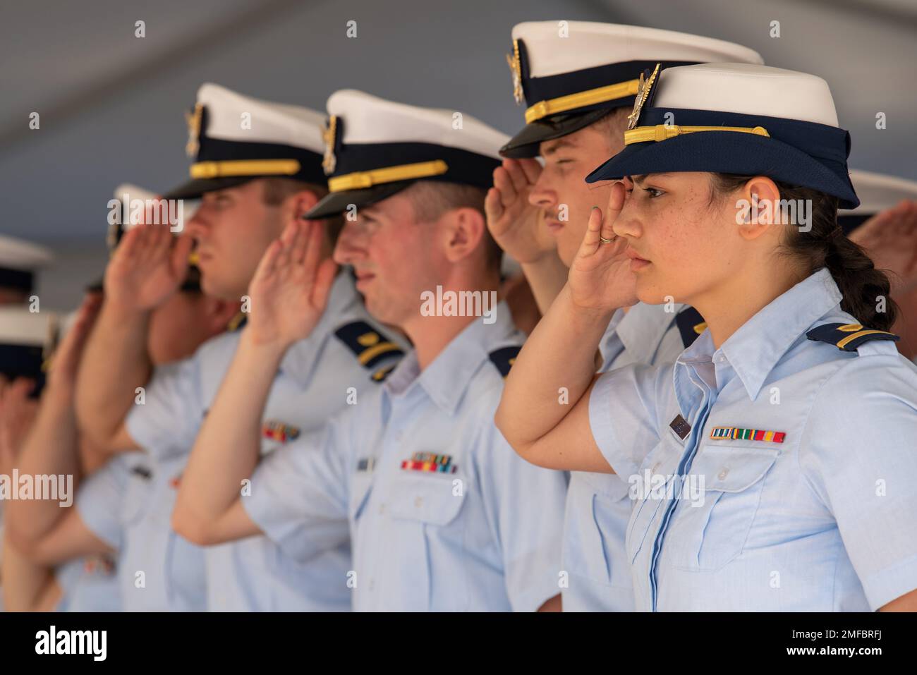 Coast Guard personnel render a salute during a ceremony at at Naval ...