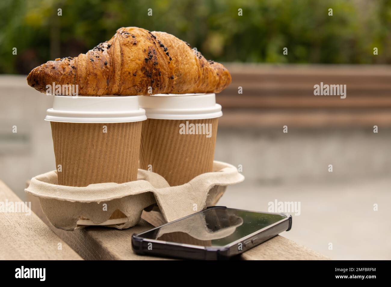 Fresh baked chocolate croissant on Two paper cups with lid for tea to ...