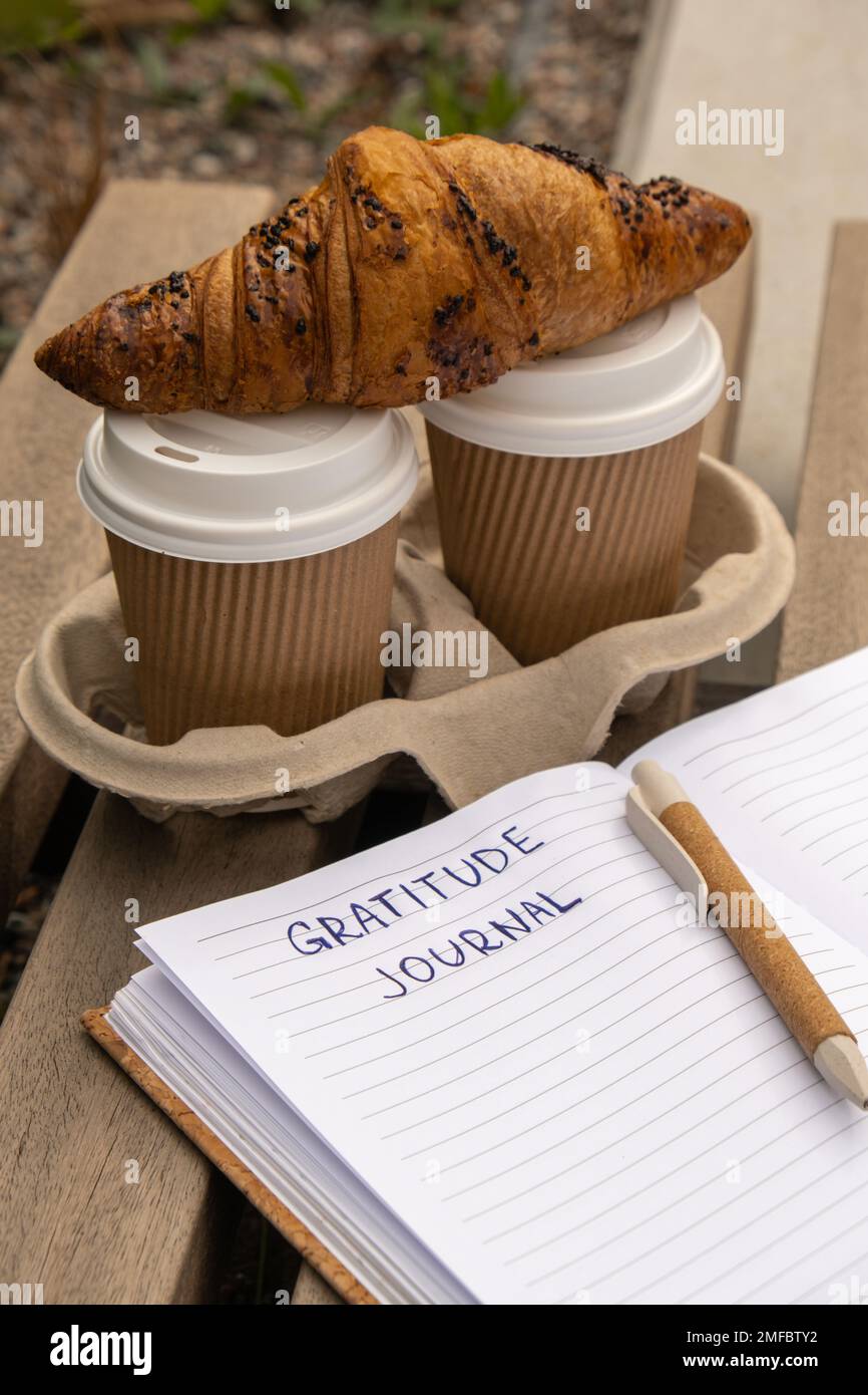 Writing Gratitude Journal on wooden bench. Coffee and croissants ...