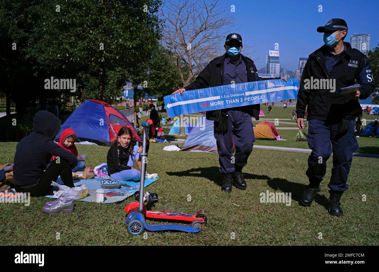 A police officer displays a banner showing social distancing to prevent ...