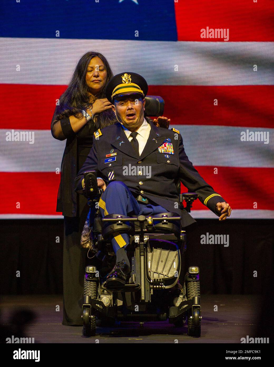 U.S. Army Cpt. Luis Avila, accompanied by his wife Claudia, sings the ...
