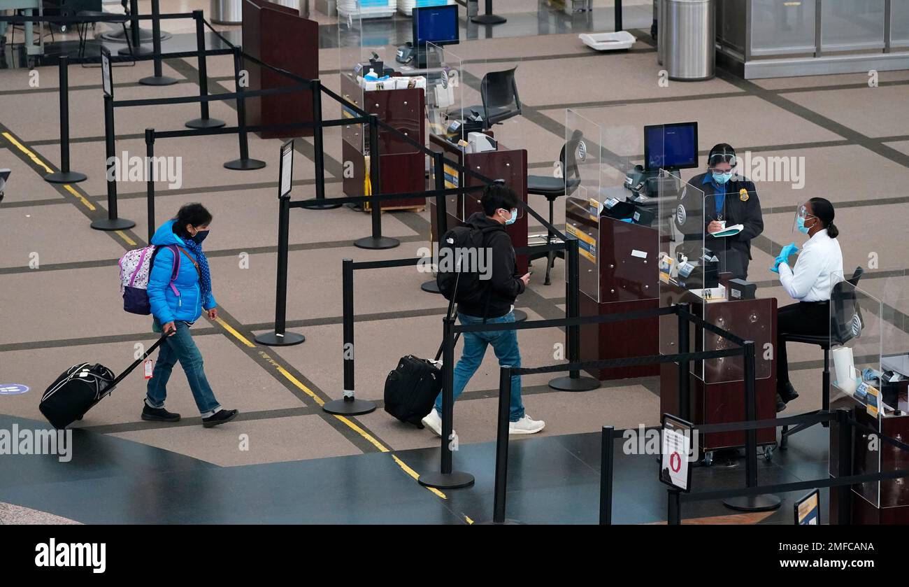 Travelers wear face masks while passing through the north security ...