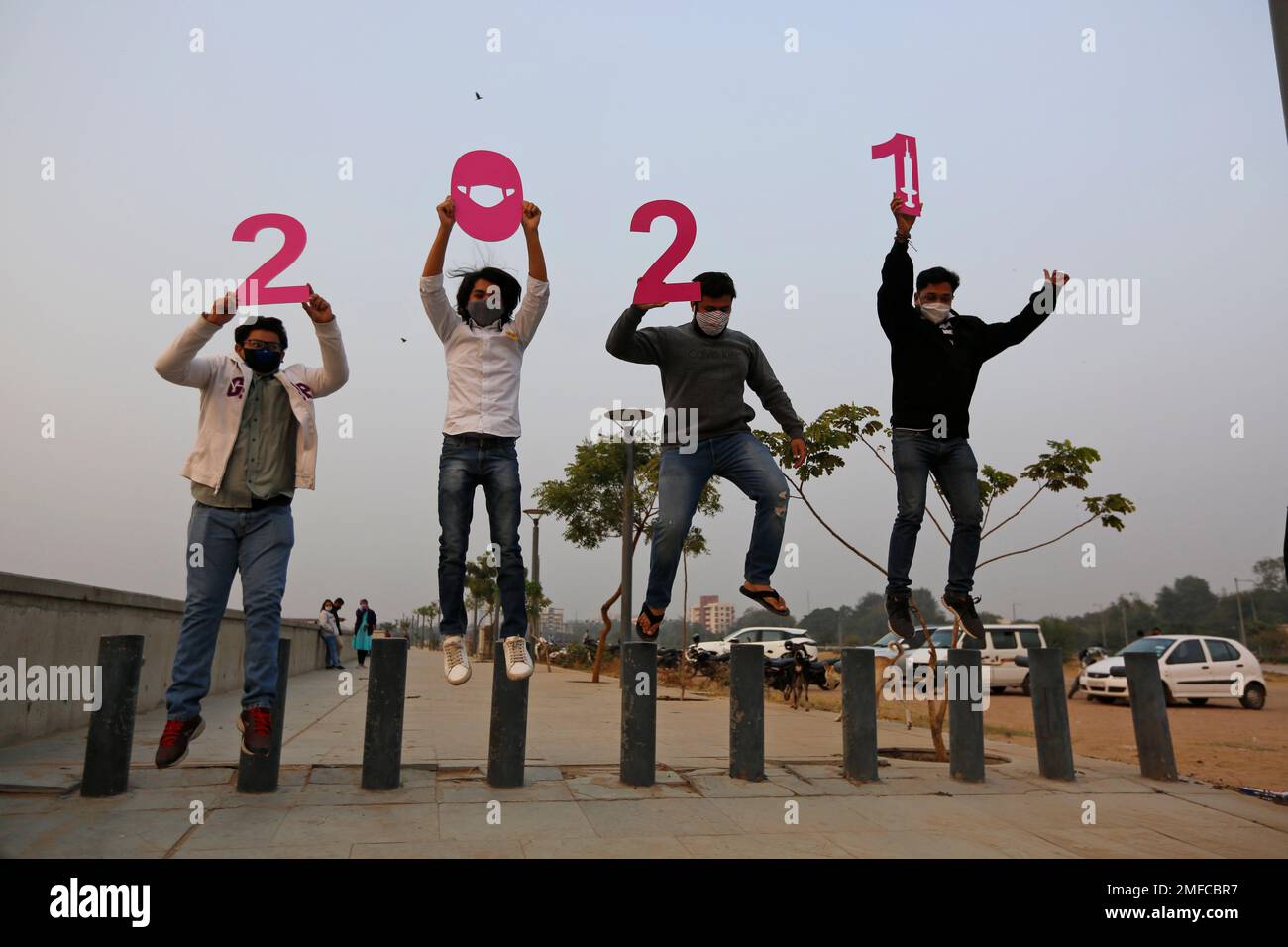 People hold cutouts to welcome the New Year in Ahmedabad, India ...