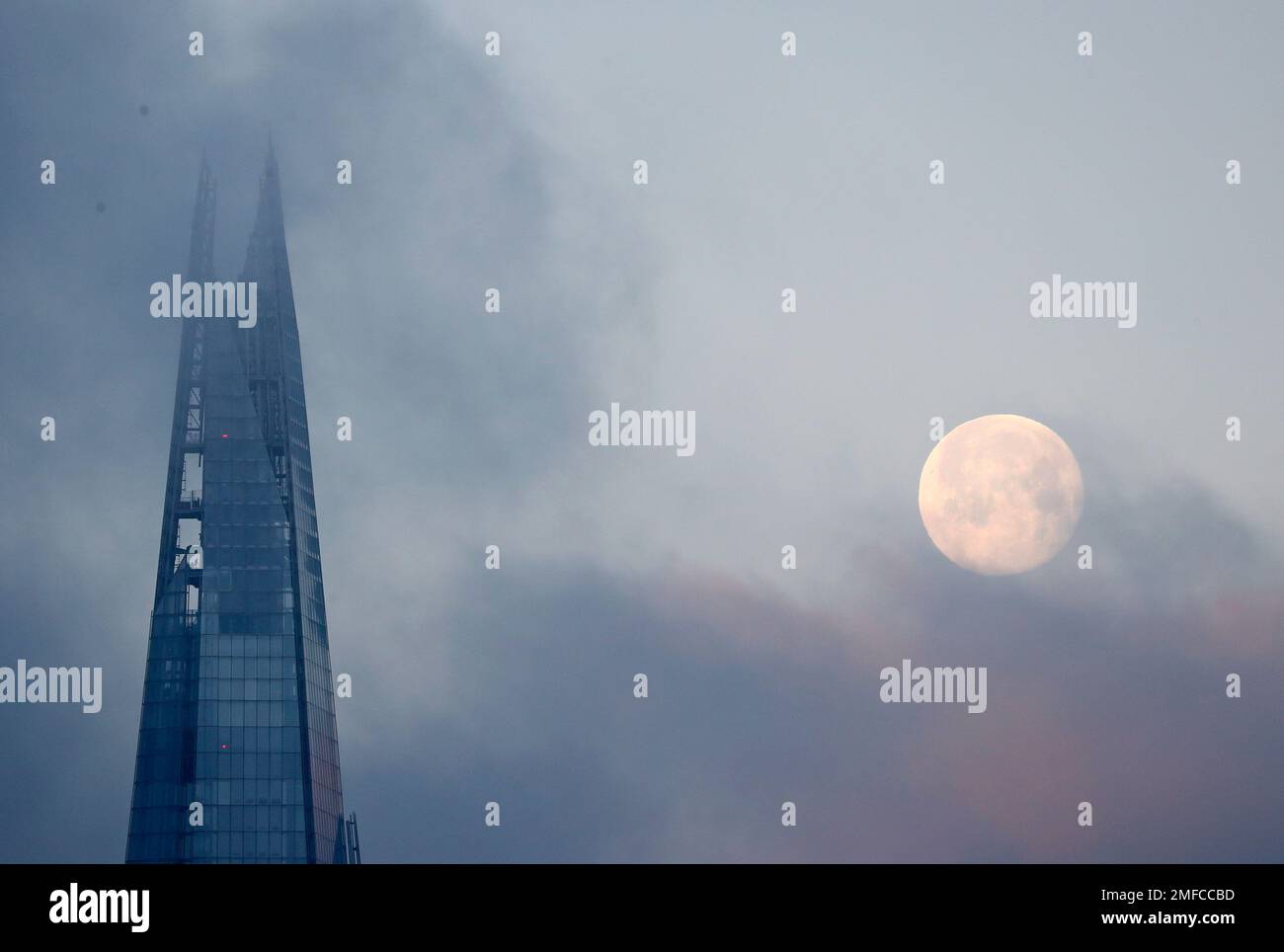 A full moon passes by the Shard skyscraper in London on Thursday Dec ...