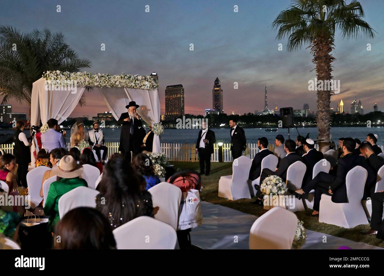 A rabbi officiates under a traditional Jewish wedding canopy during ...