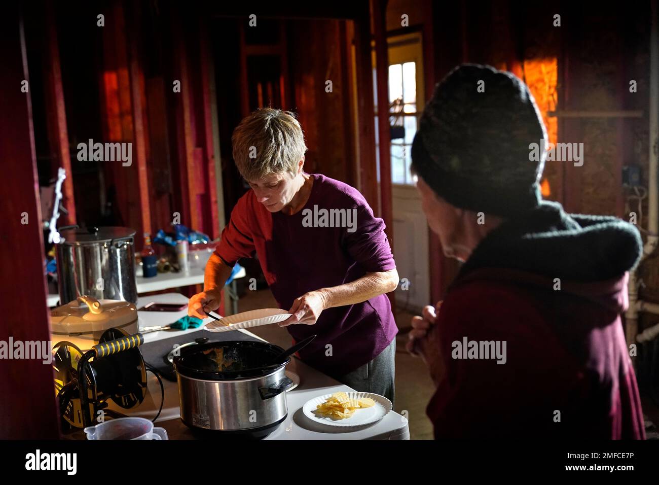 Mary Ann Unson serves food to her mother Lou Ann Trahan, who lives with ...