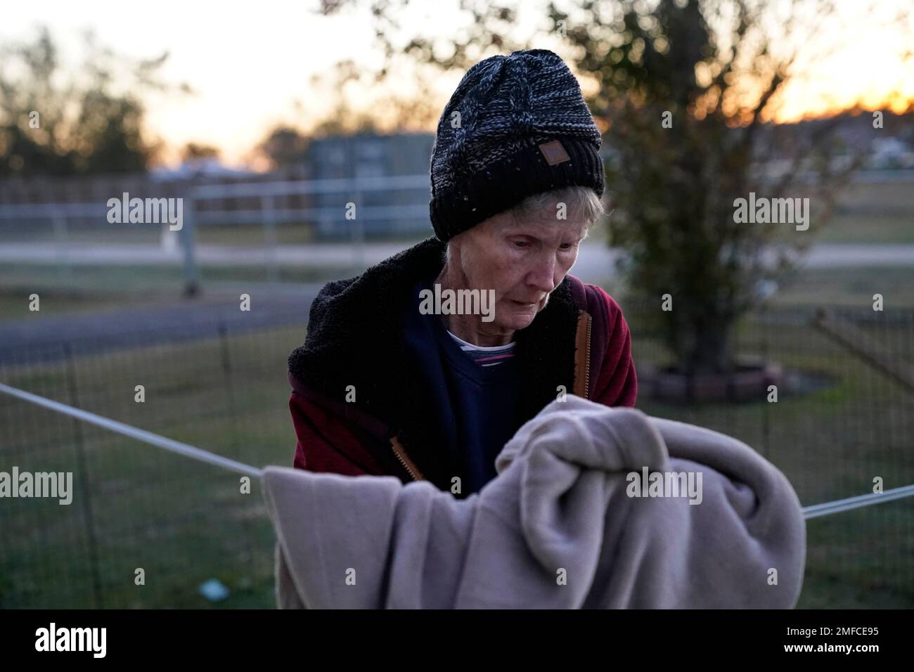 Lou Ann Trahan, who suffers from dementia, takes a blanket off a ...