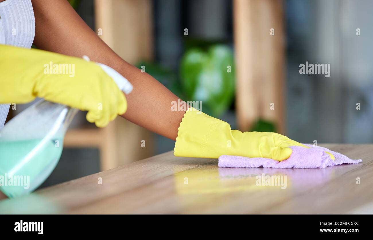 Woman cleaner, spray and cloth on table for hygiene, health or safety ...