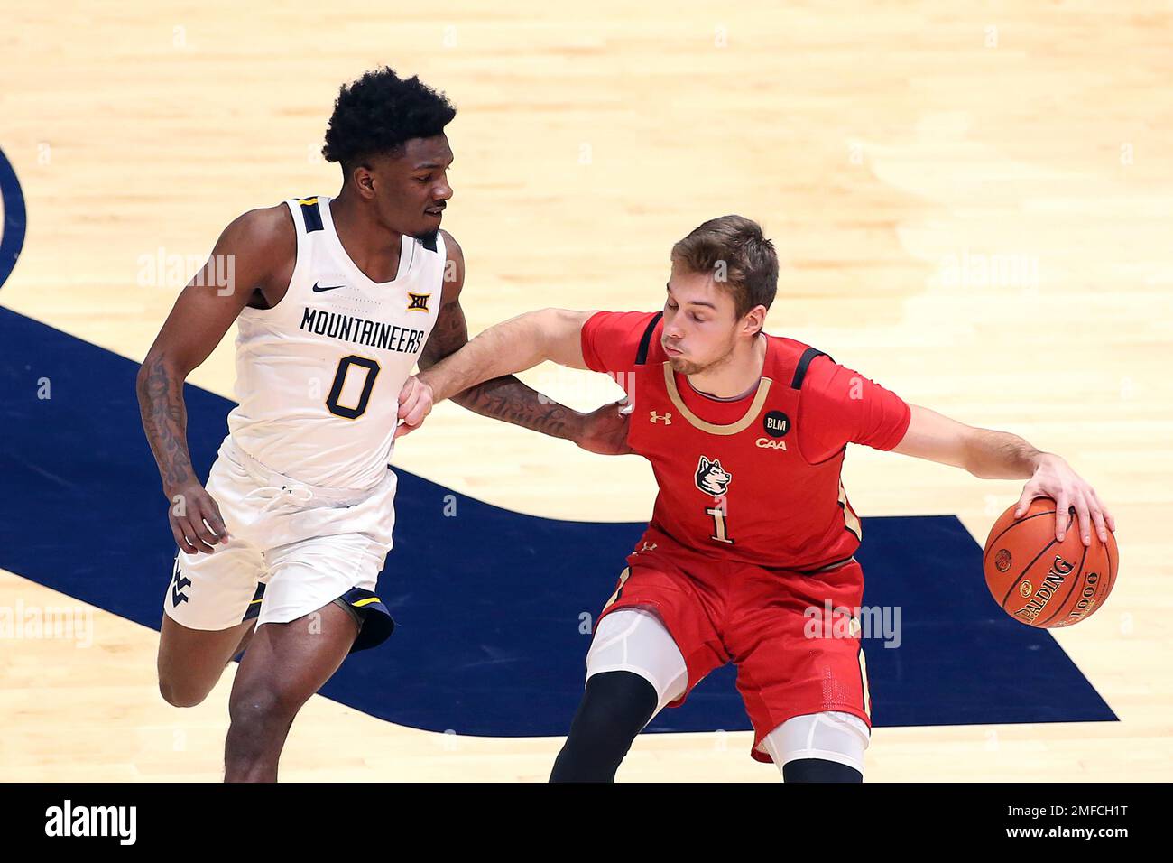Northeastern guard Vito Cubrilo (1) is defended by West Virginia guard ...