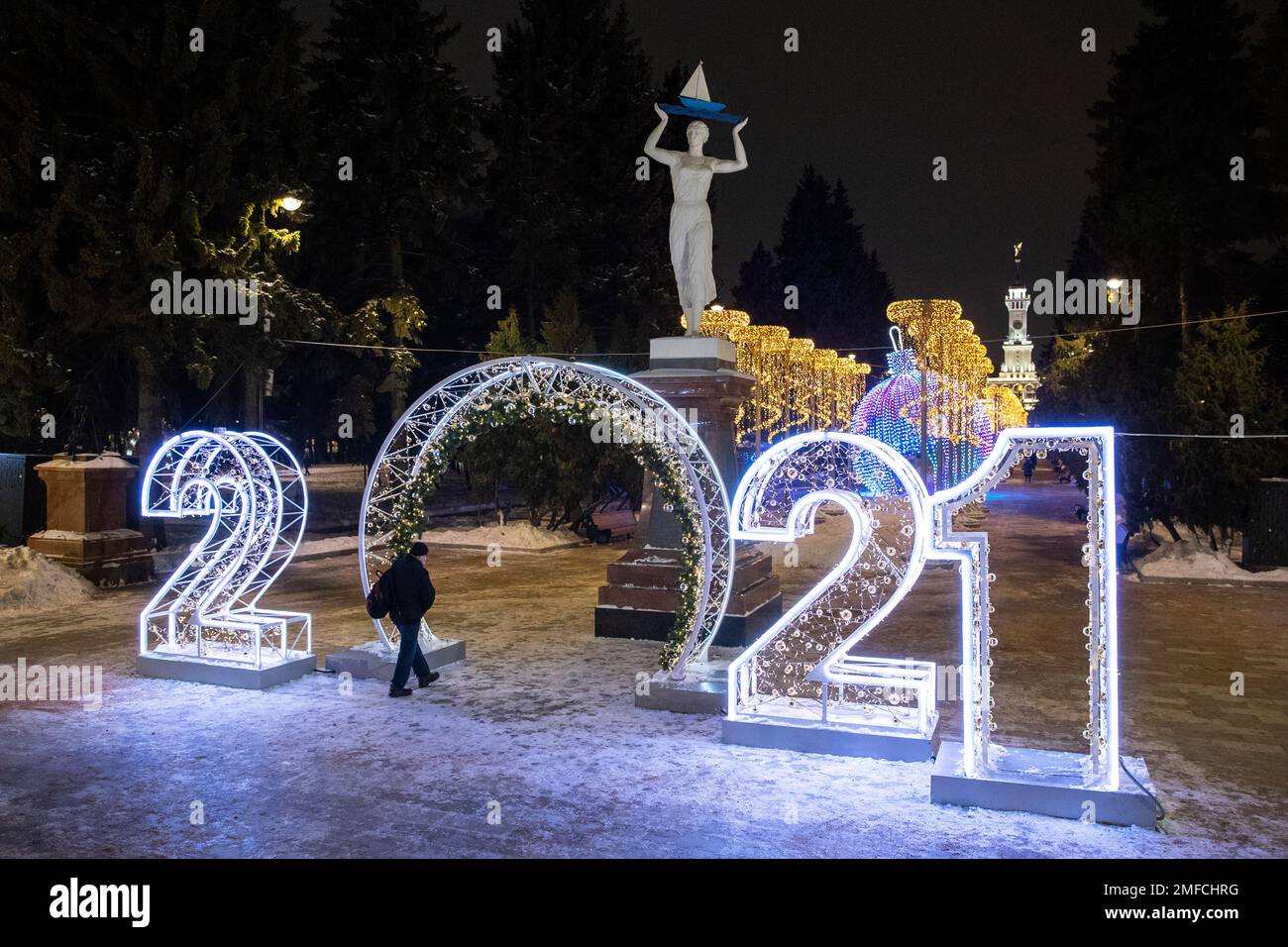 A man passes "2021" numbers installed to celebrate the upcoming New ...