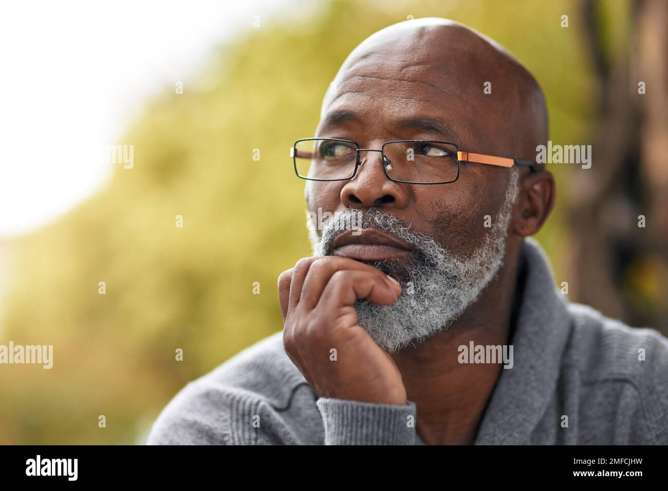 Hes got a lot on his mind. a handsome senior man looking thoughtful ...