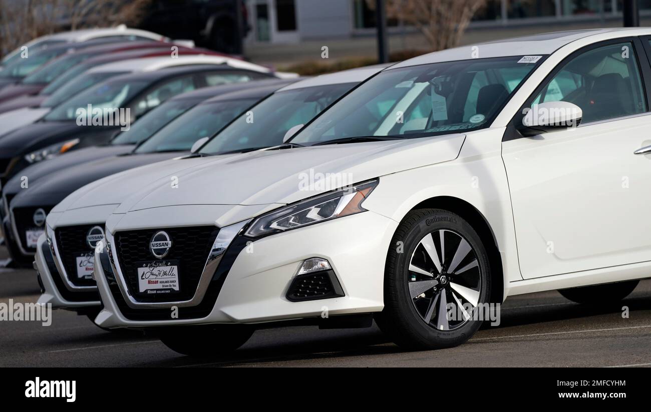 A long row of unsold 2021 Altima sedans sits at a Nissan dealership ...